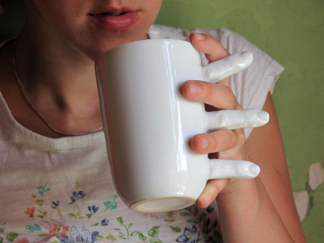 A Mug With Three Human Fingers Serving as the Handle