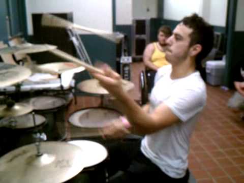 A Drummer Simultaneously Juggling and Drumming With 3 Drum Sticks