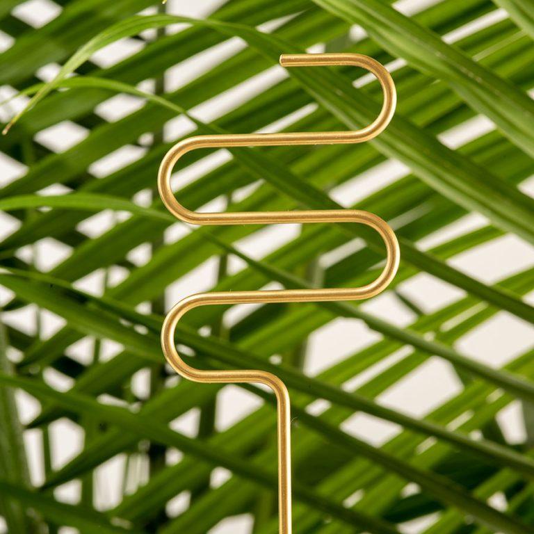 Shiny Brass Sticks That Give Support to Growing Plants